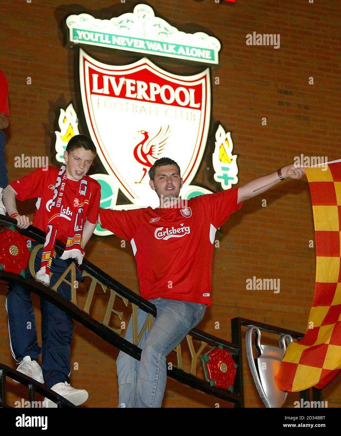Liverpool fans sit ontop of the Paisley Gates at Anfield to celebrate ...