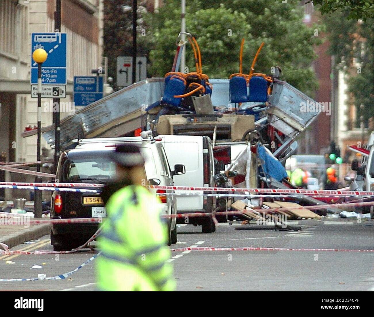 The bus hit by the bomb sits in Tavistock Square, as police officers ...