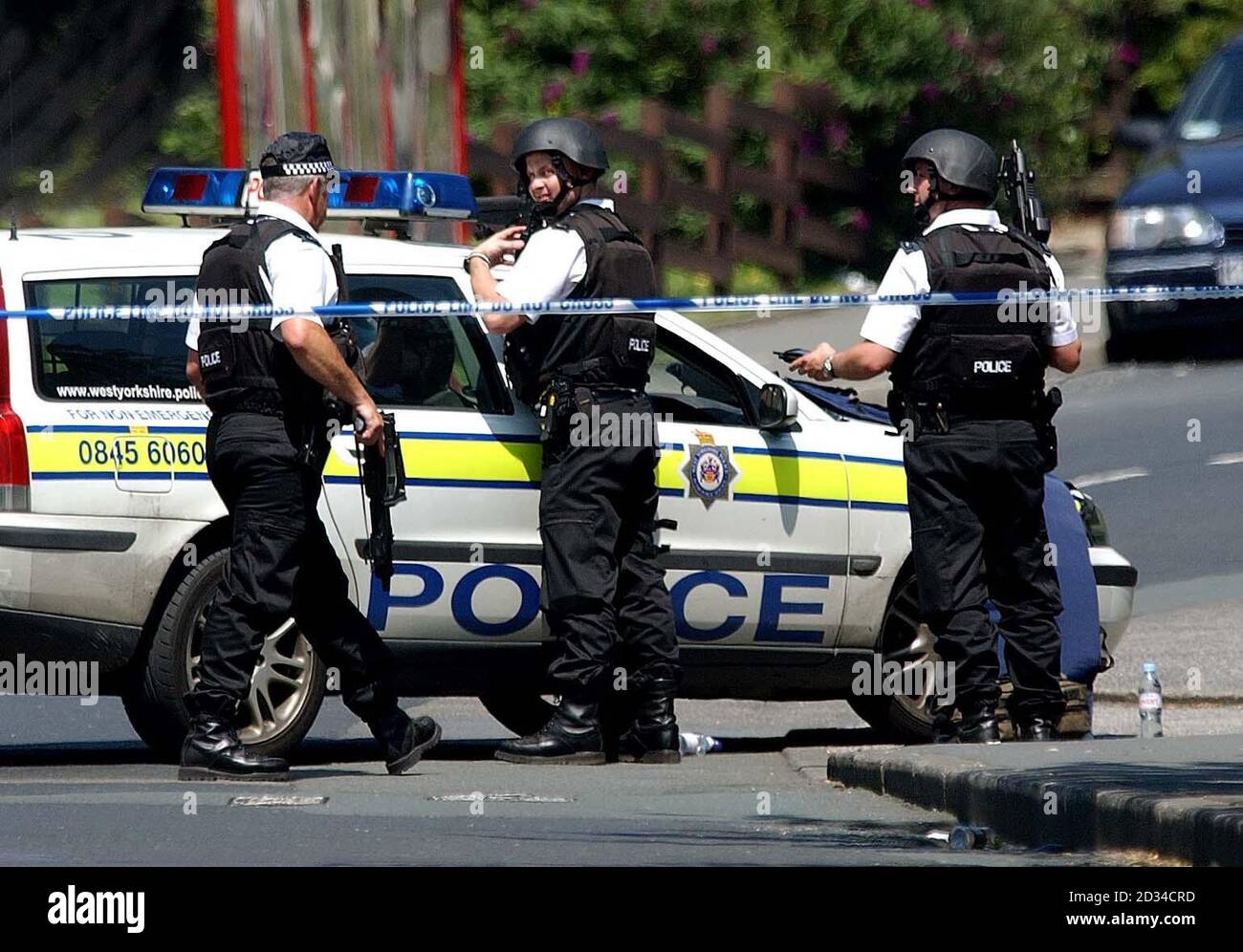 Armed police took up positions outside a house in Leeds today during a ...