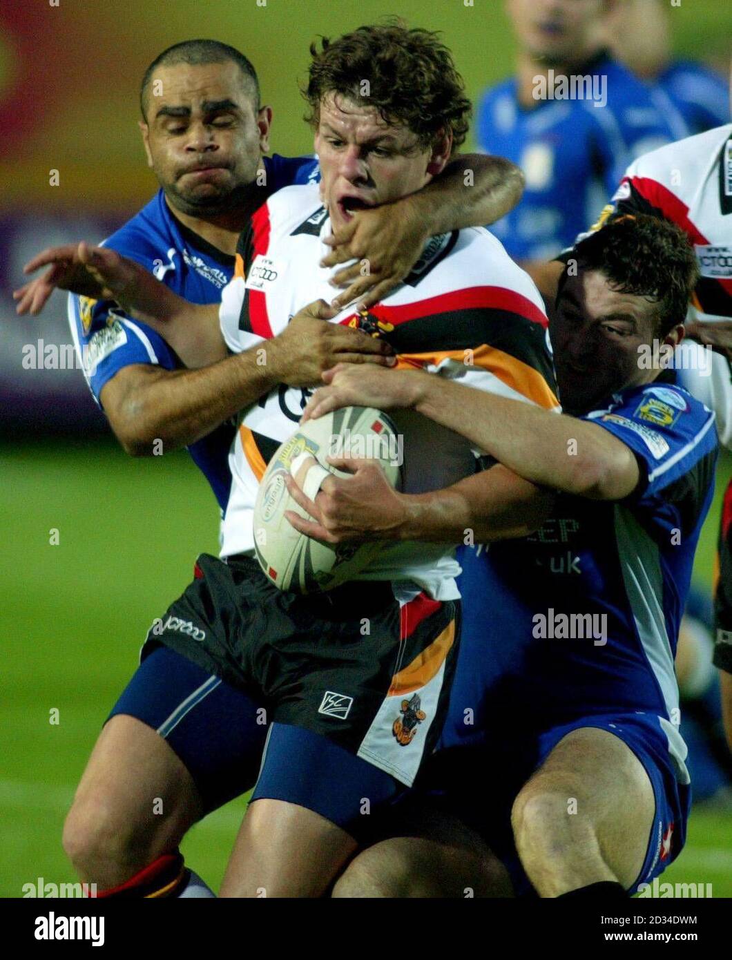 Bradford's Lee Radford (C) is tackled by Hull FC's Nathan Blacklock (L ...
