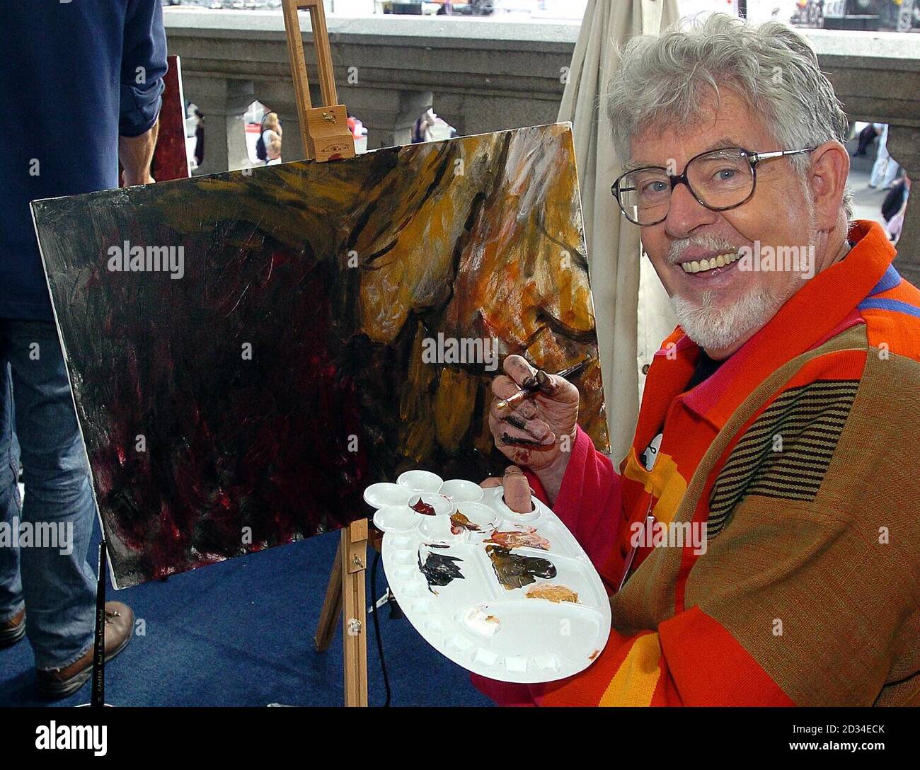 Australian artist Rolf Harris putting the final touch to his canvas ...