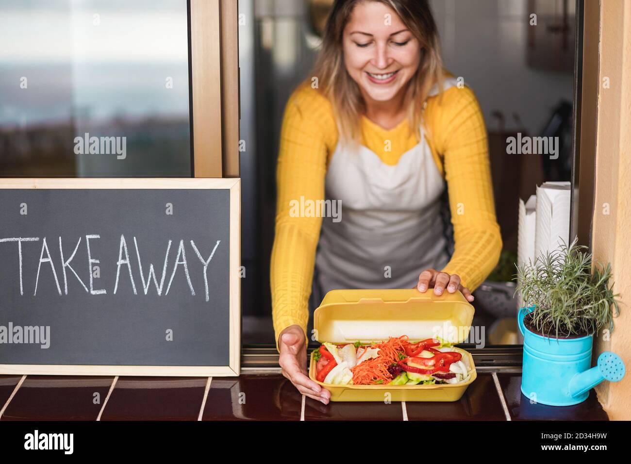 Happy woman preparing takeaway organic food order inside plastic free ...