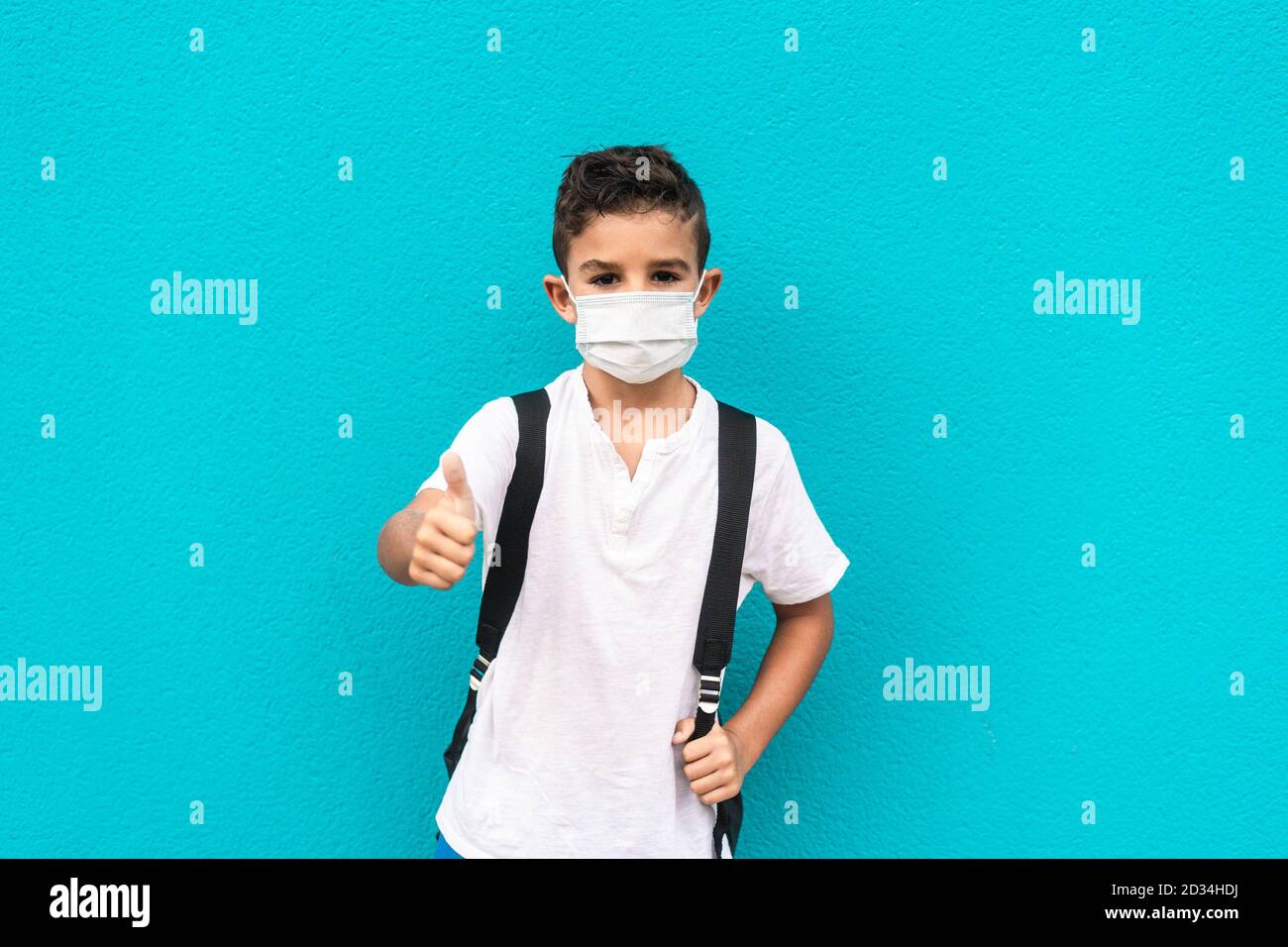 Little kid with face mask going back to school with thumbs up during ...