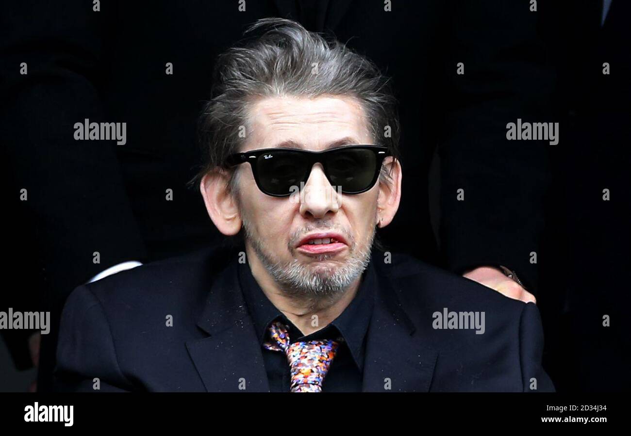 Singer Shane MacGowan is helped from the church as the funeral of his ...