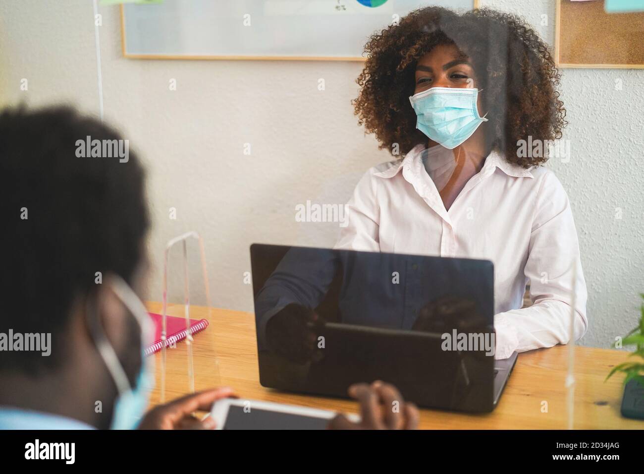 African co-workers using laptops inside creative office during ...