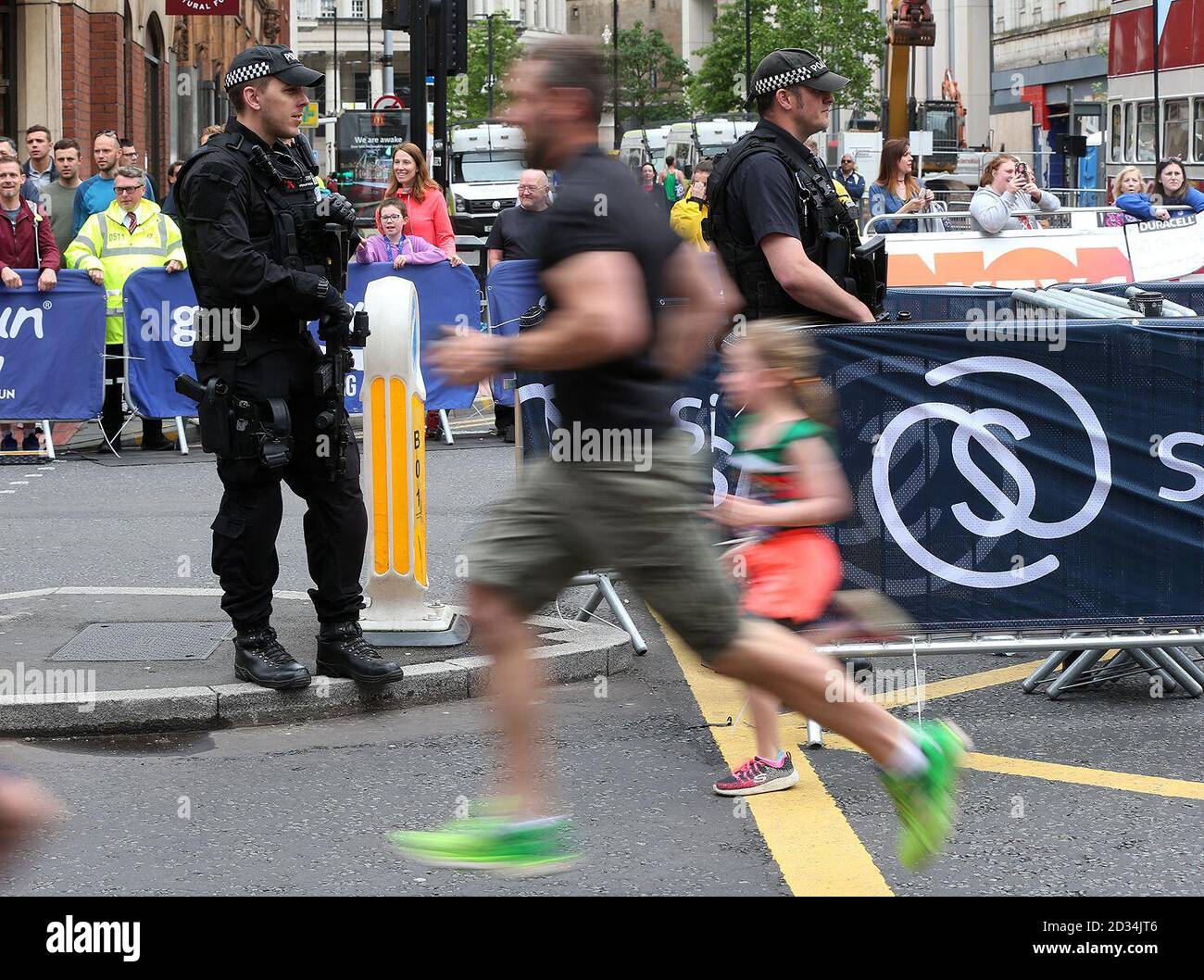 Armed police officers on patrol as thousands of defiant runners and ...