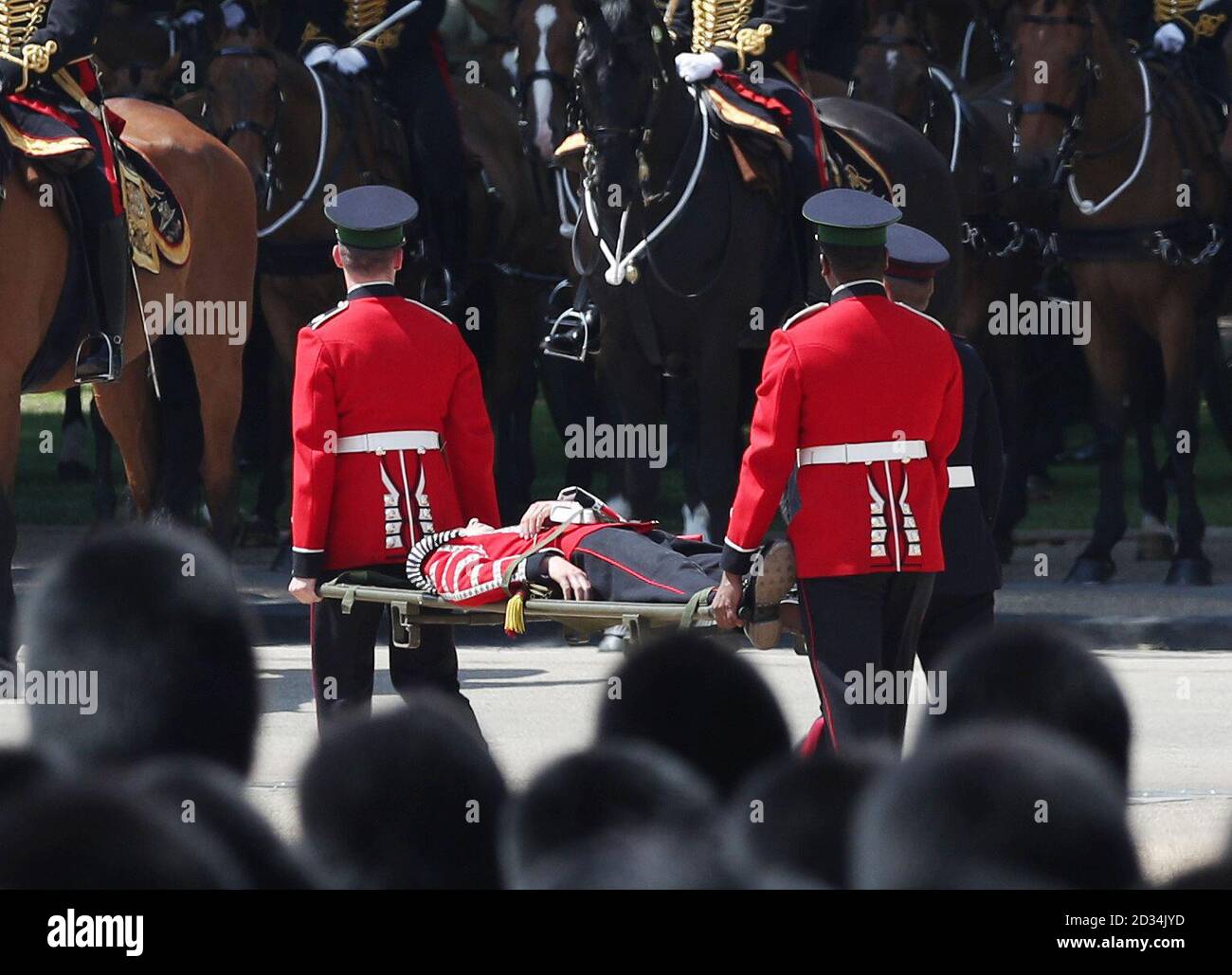 A Guardsman is carried off after fainting during the Trooping the ...