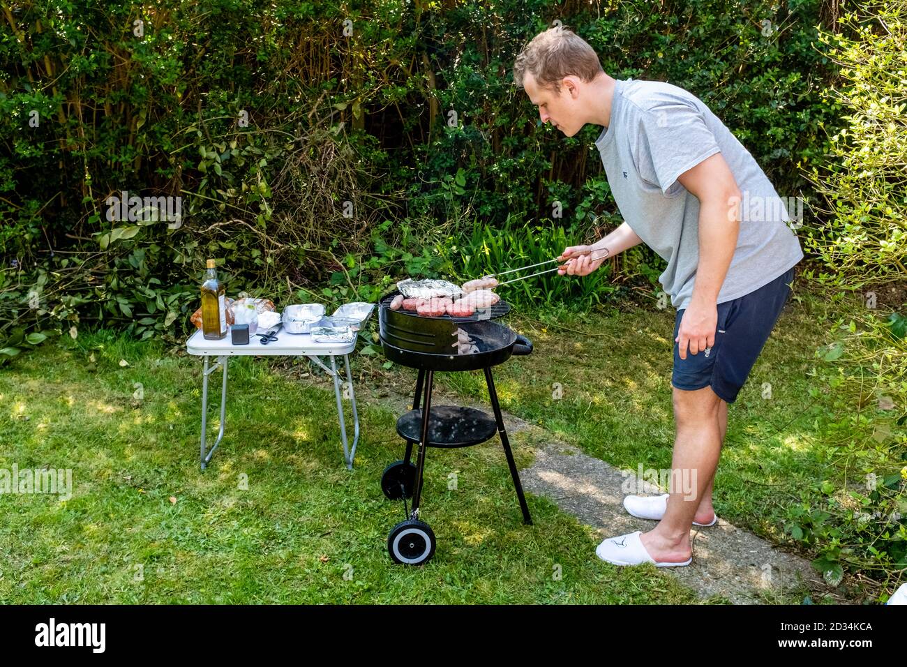 A Young Man Cooking Food On A Barbeque, East Sussex, UK Stock Photo - Alamy