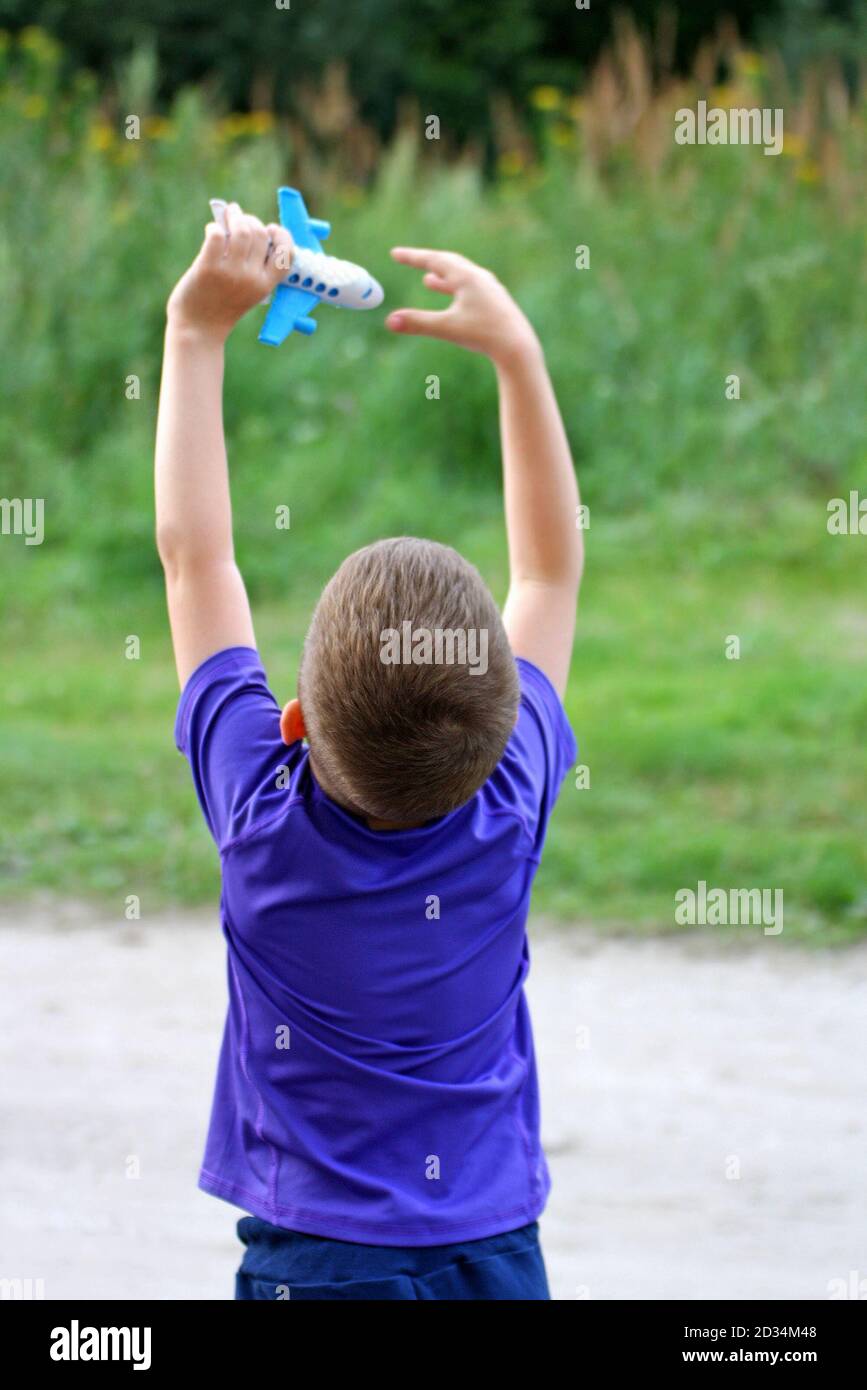 Children's outdoor play. A child plays with an airplane. The boy raised ...