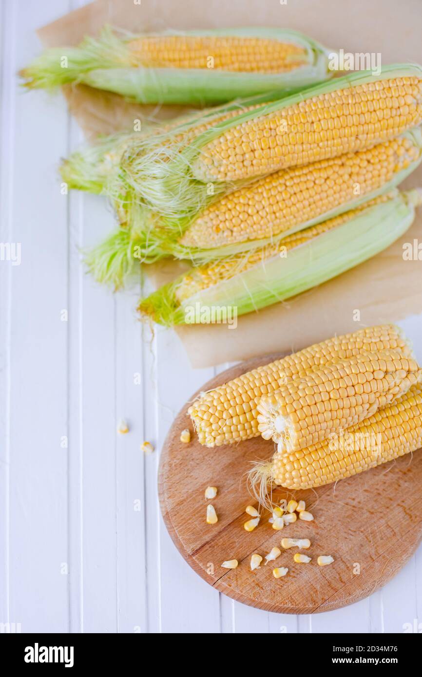 Group sweet corn on the table. Fresh corn on cobs on rustic wooden ...