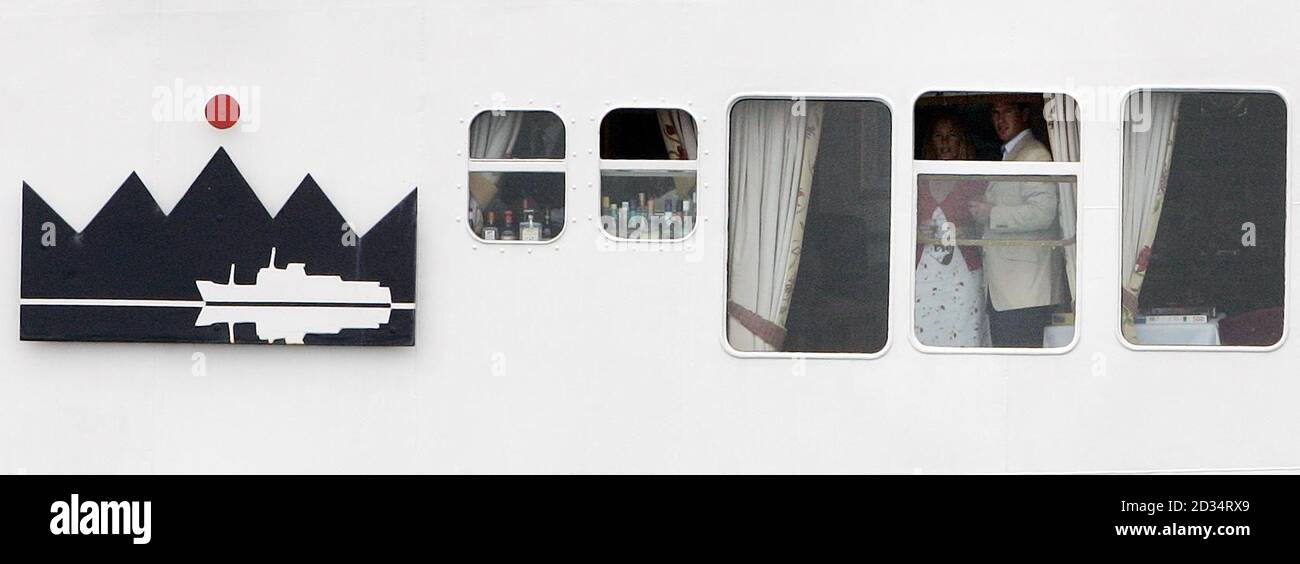 Peter Phillips and his girlfriend, Autum Kelly look from a window as ...