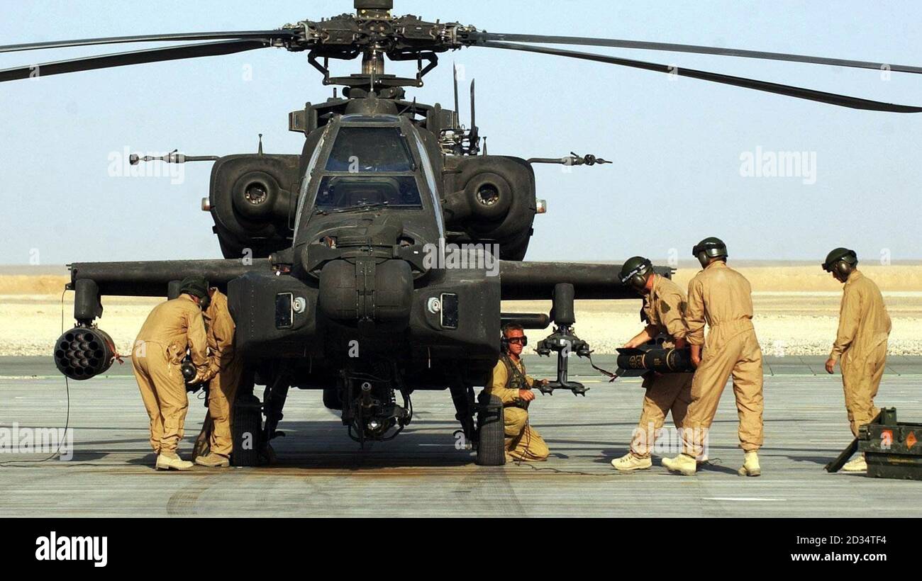 An Attack Helicopter Arming Team fitting Hellfire missiles to an Apache ...