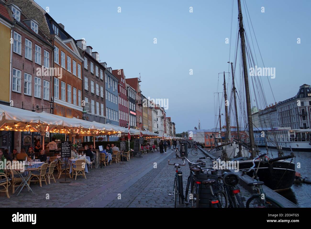 Copenhagen, Europe, Nyhavn promenade with restaurants, ships and houses ...