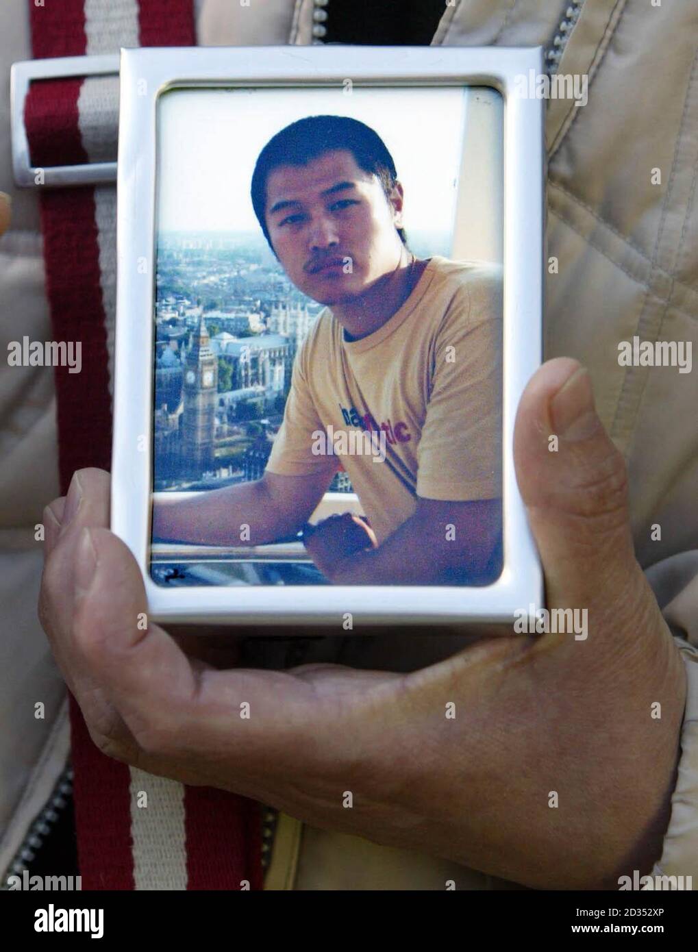 Chun Xiang Zhang, mother of Song Zhi, holds a picture of him outside ...