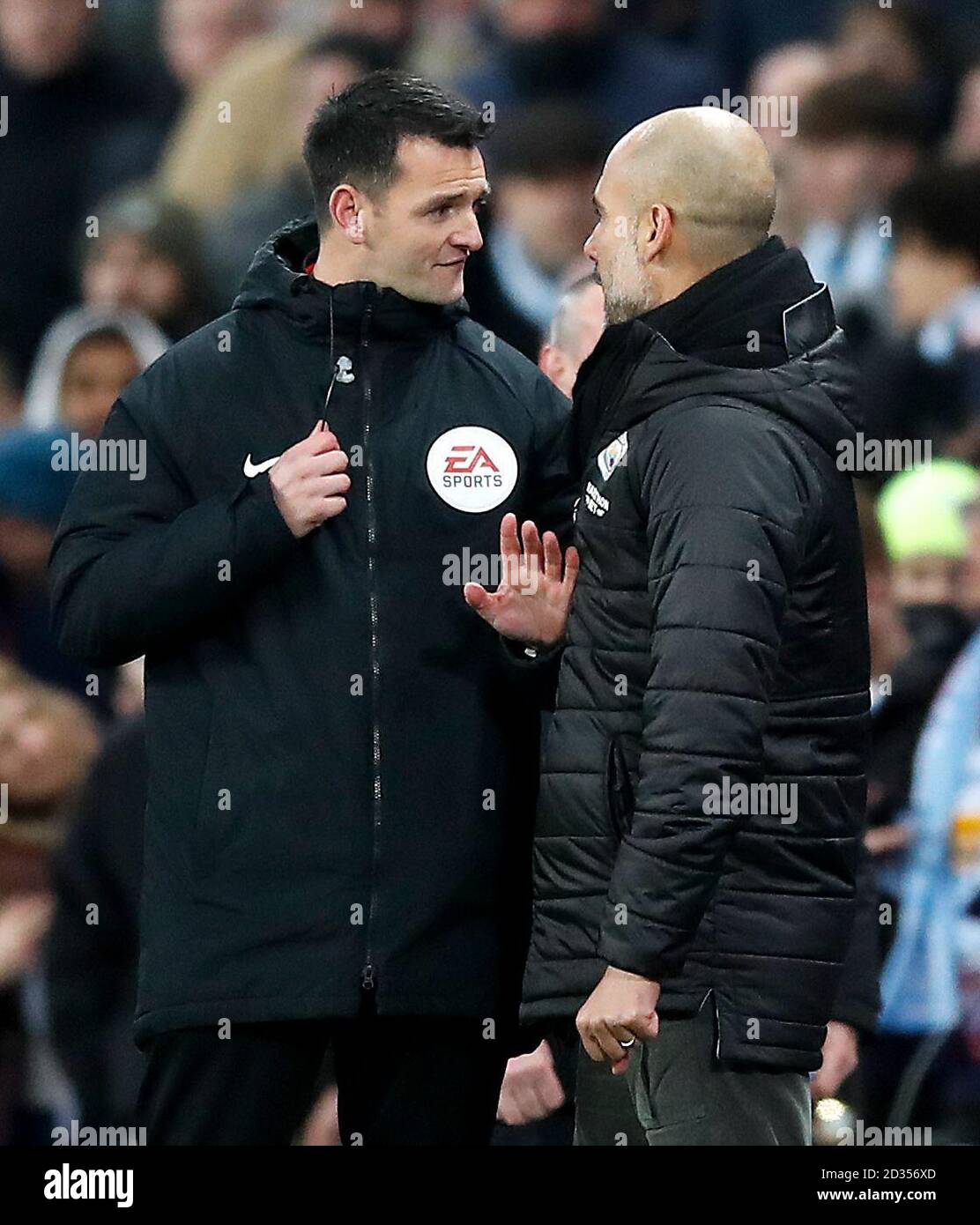 Manchester City manager Pep Guardiola (right) speaks with fourth ...