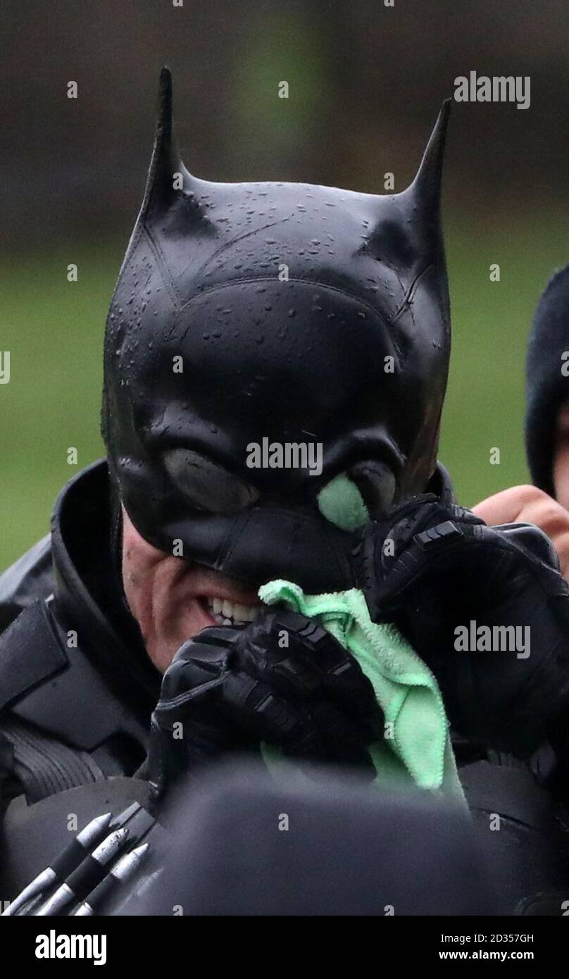 A man dressed as Batman has his face wiped during filming at the ...