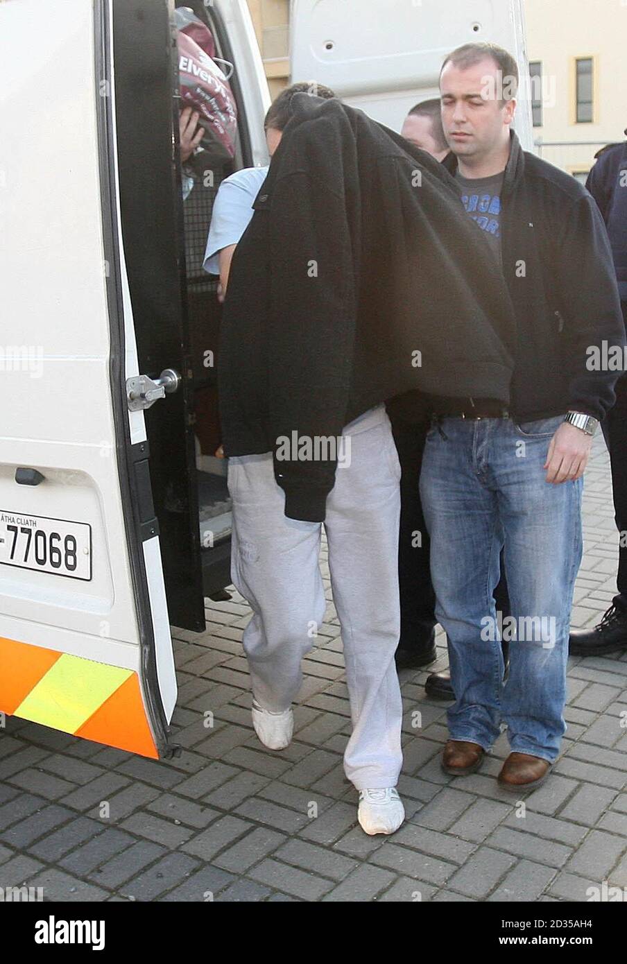 Paul Drew covers his face as he arrives at Tallaght Court house in west ...