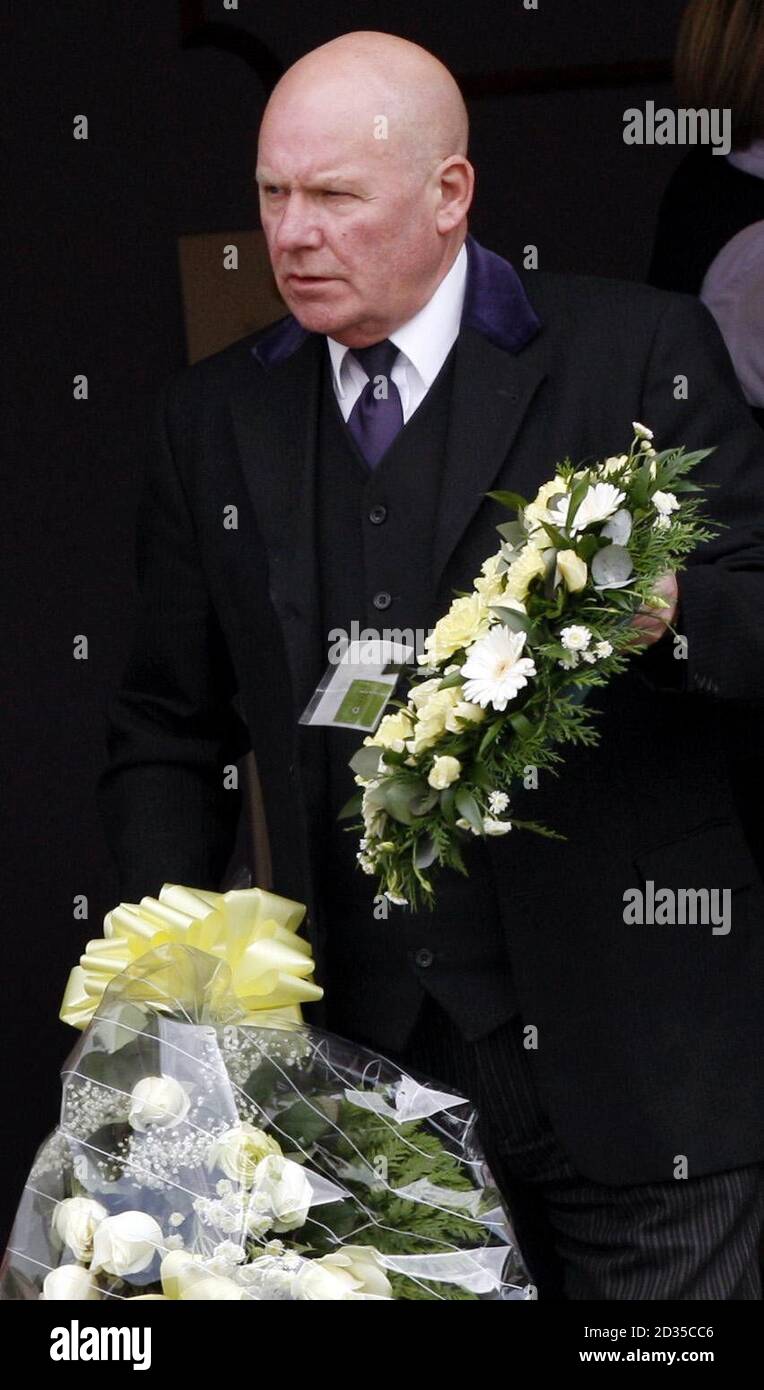 Floral tributes are carried from the Co-op funeral parlour in Glasgow ...