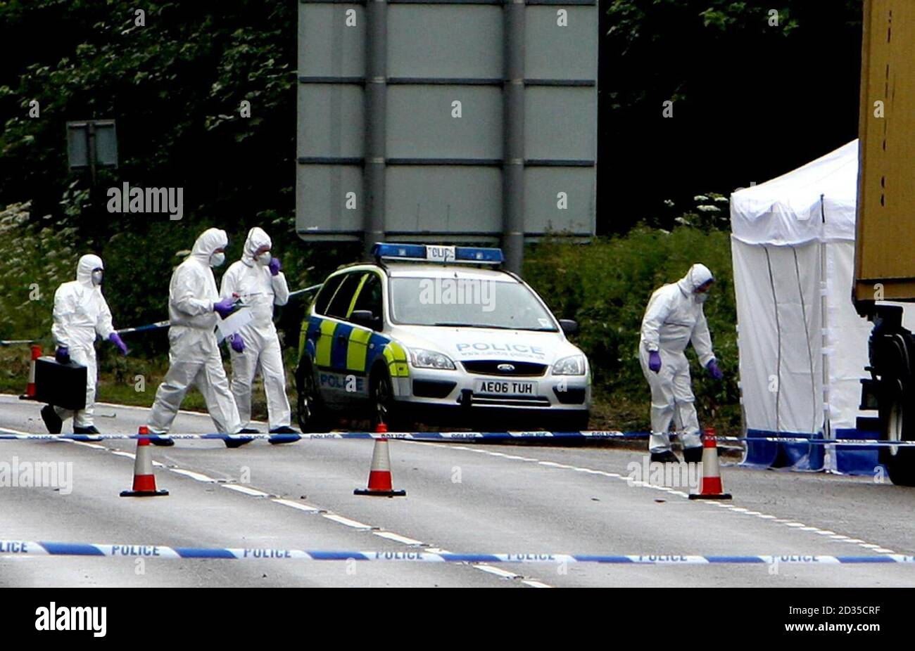 Police forensic officers attend the scene on the A1031 at Hinxton ...