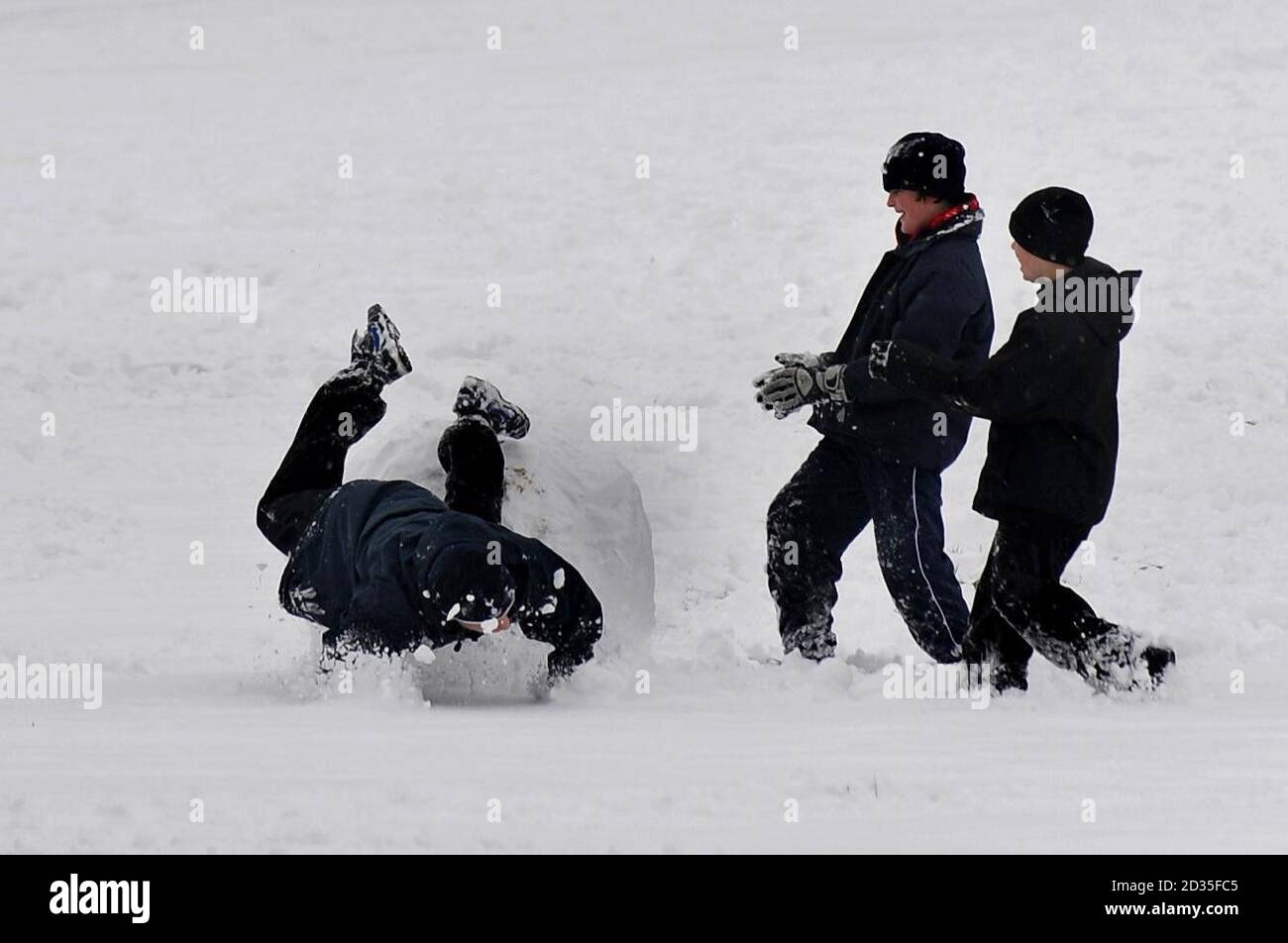 A boy falls over a large snowball in Harrow-on-the-Hill, Middlesex ...
