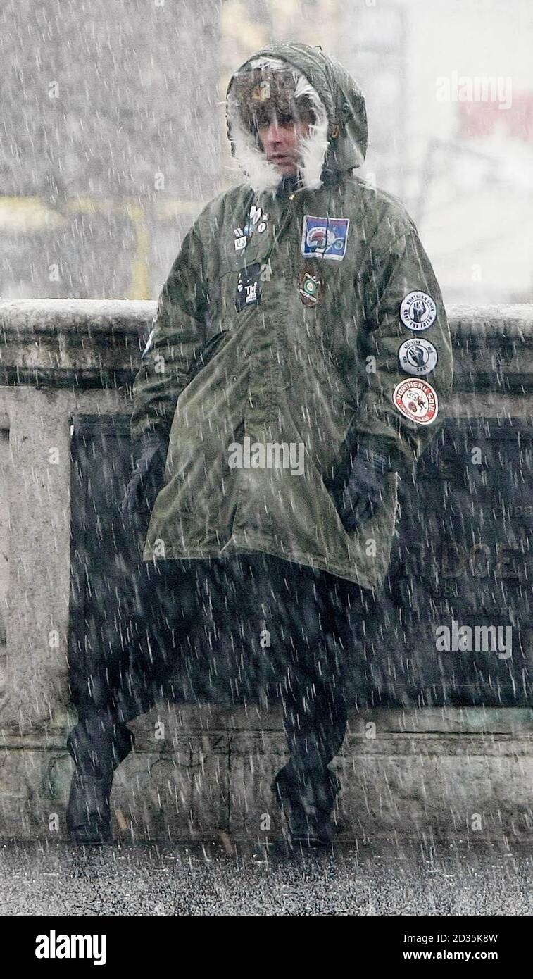 A member of the public stands on the street during a hail shower in ...
