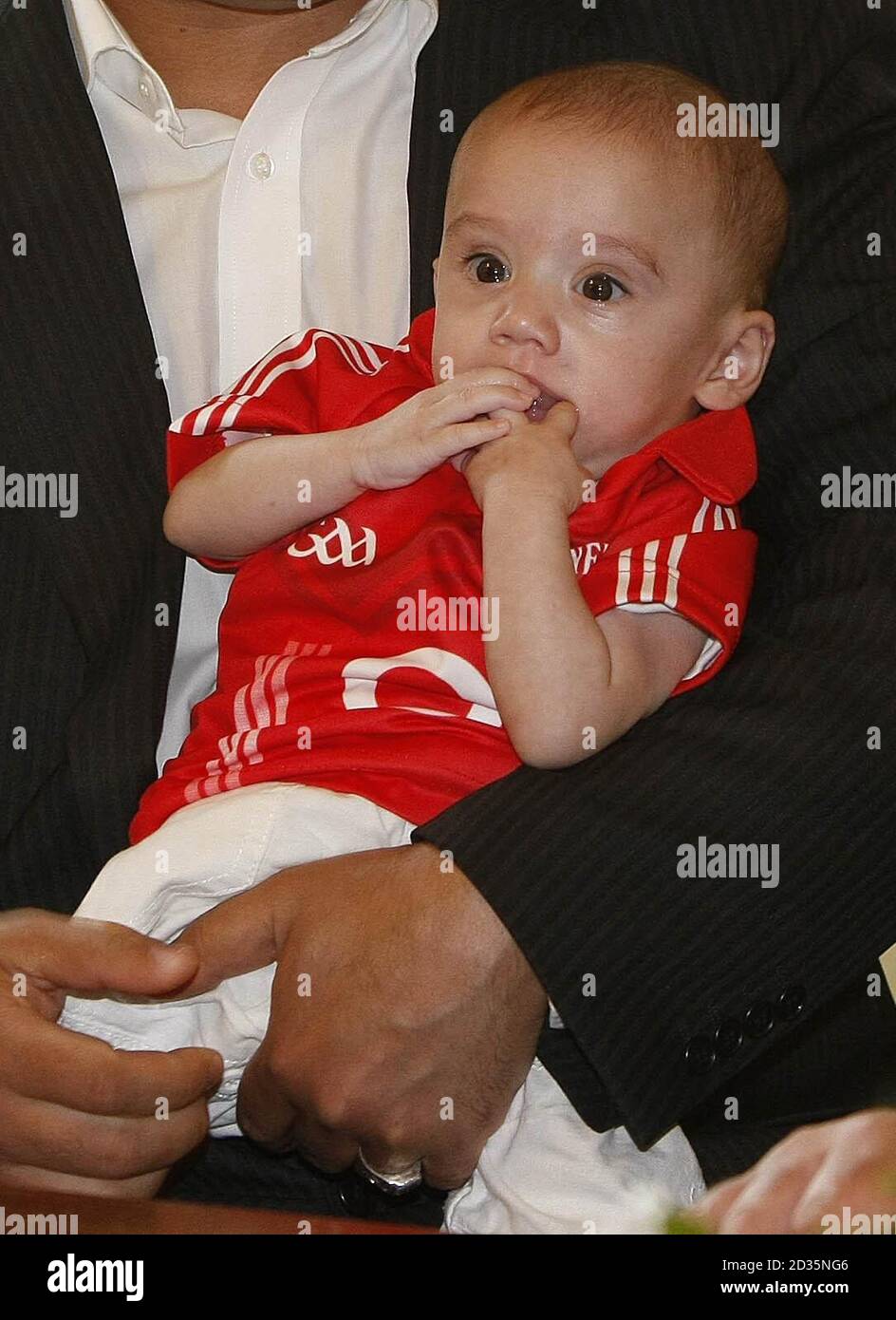 Azzedine Benhaffaf holds his son Hussein as his wife Angie holds twin ...