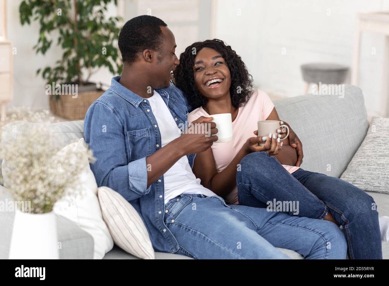 Black lovers drinking tea and laughing at home Stock Photo - Alamy