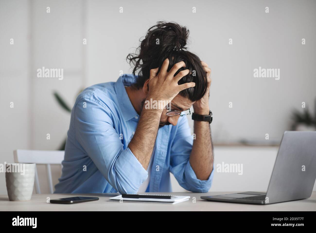 Work Problems. Desperate indian manager sitting at desk in office ...