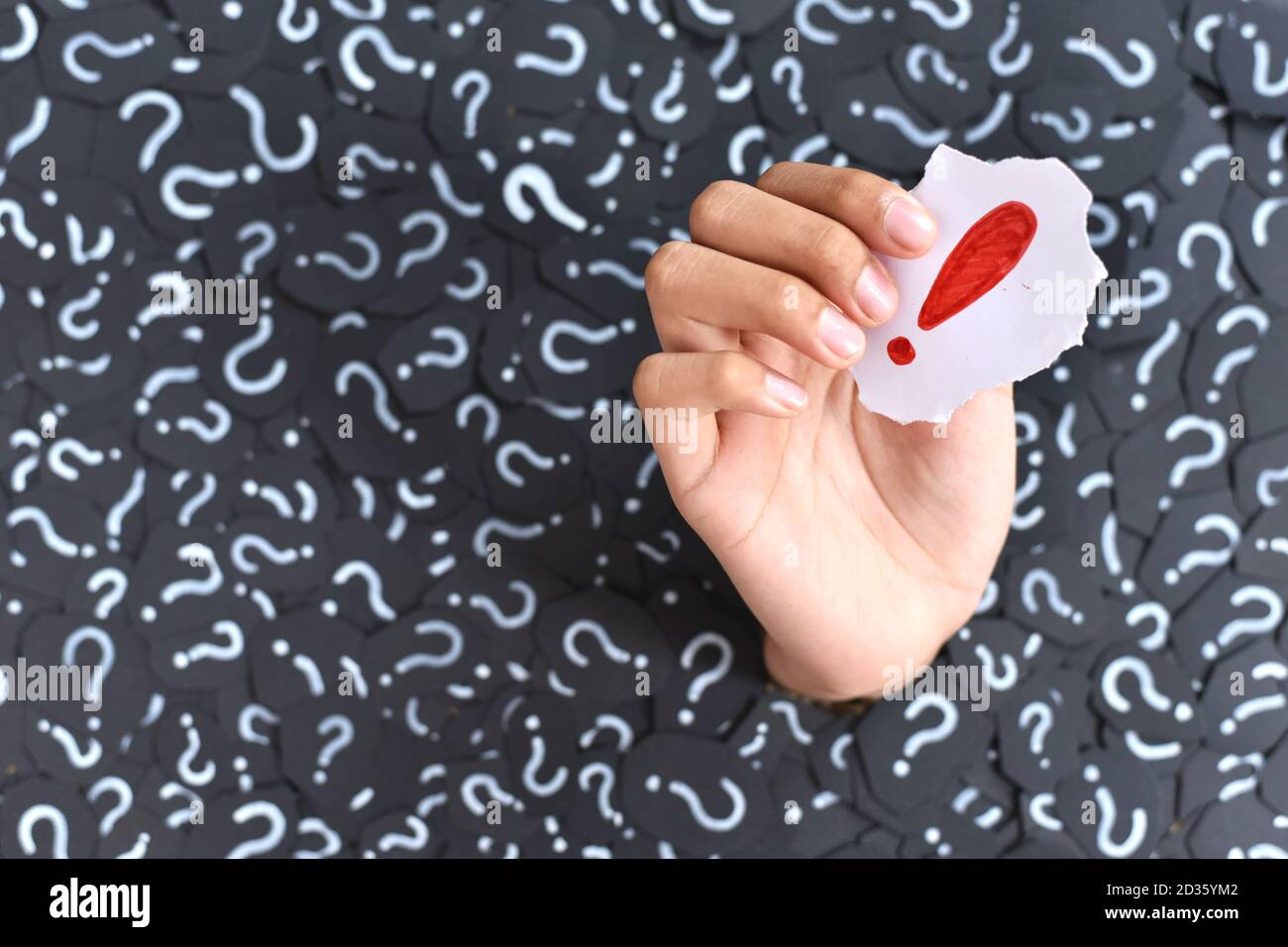 Hand holding an Exclamation Mark against Question Mark backgrounds ...