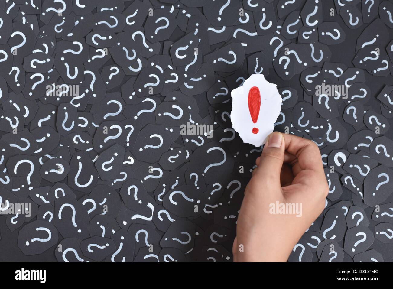 Hand holding an Exclamation Mark against Question Mark backgrounds ...
