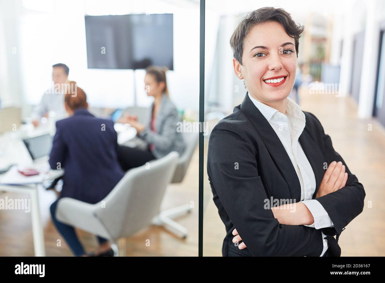 Smiling business woman as a successful manager in front of her team in ...