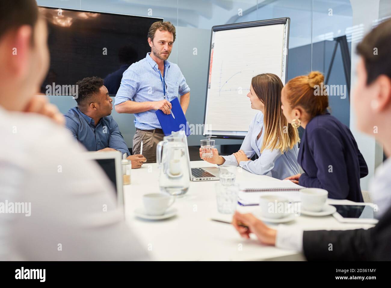 Business consultant giving a presentation on a flipchart in a coaching ...
