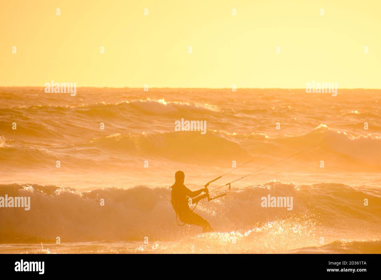 Surfer at sunset on a calm ocean Stock Photo - Alamy