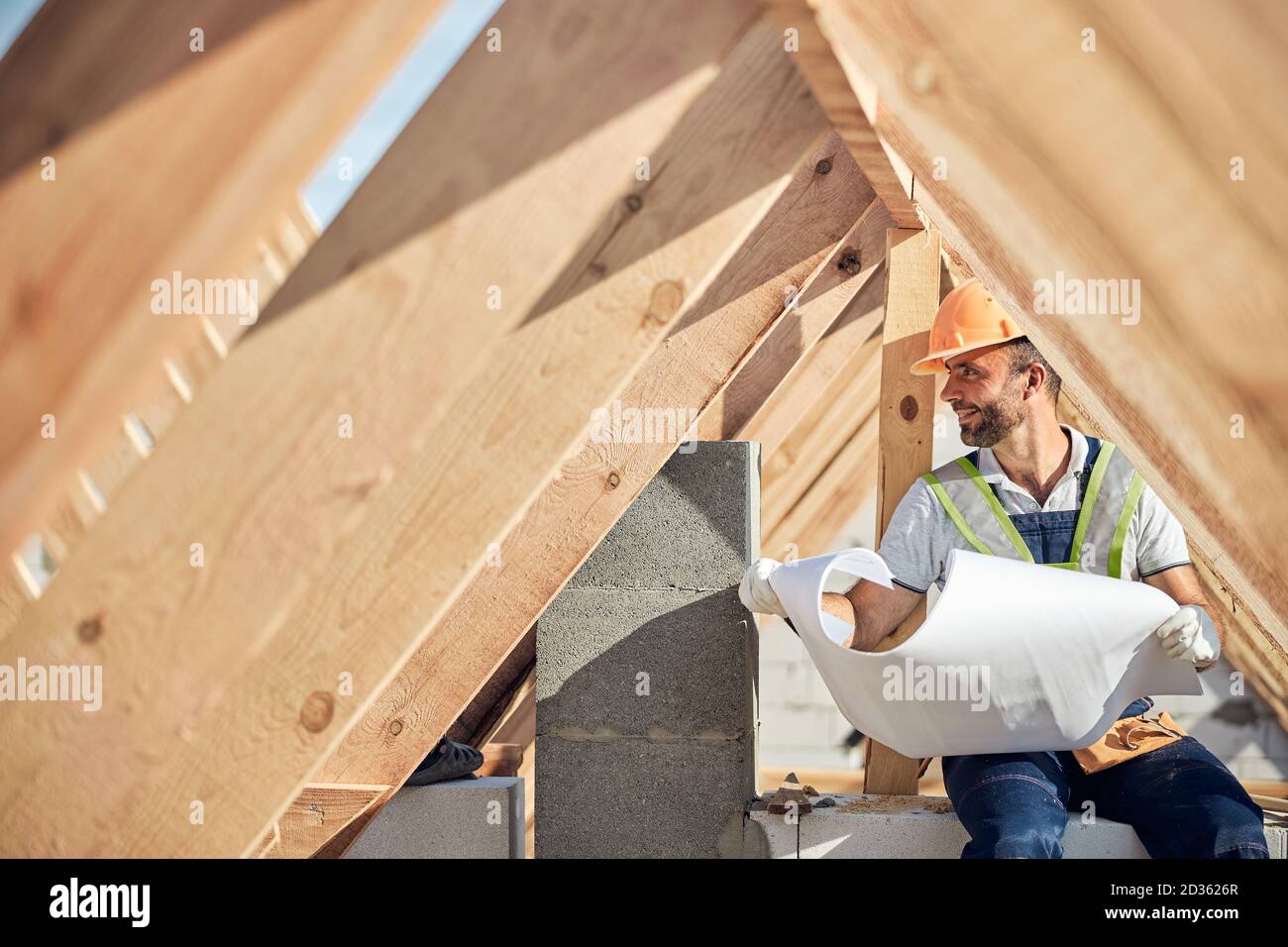 Contented man holding a blueprint of a new building Stock Photo - Alamy