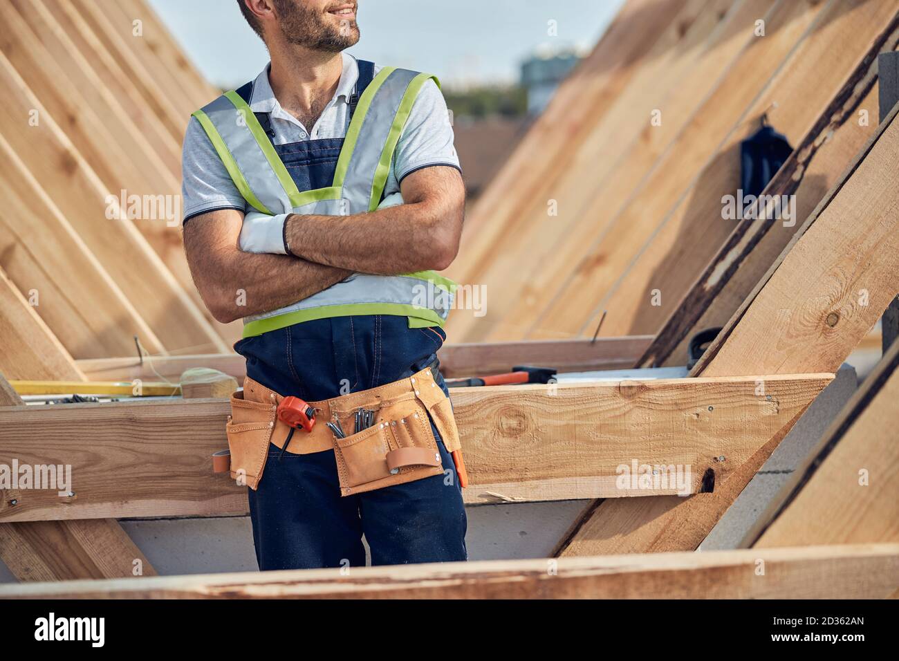 Proud builder in uniform posing with arms crossed Stock Photo - Alamy
