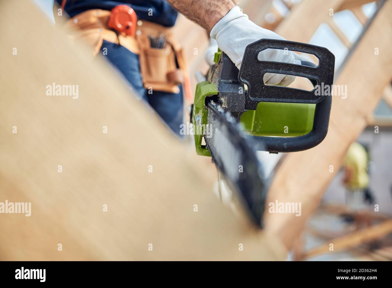 Qualified construction site worker using a chainsaw Stock Photo - Alamy