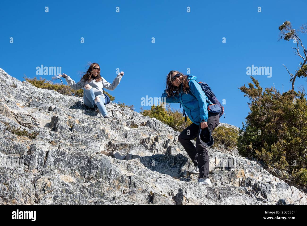 Mother and daughter climb and rest on cliff Stock Photo - Alamy