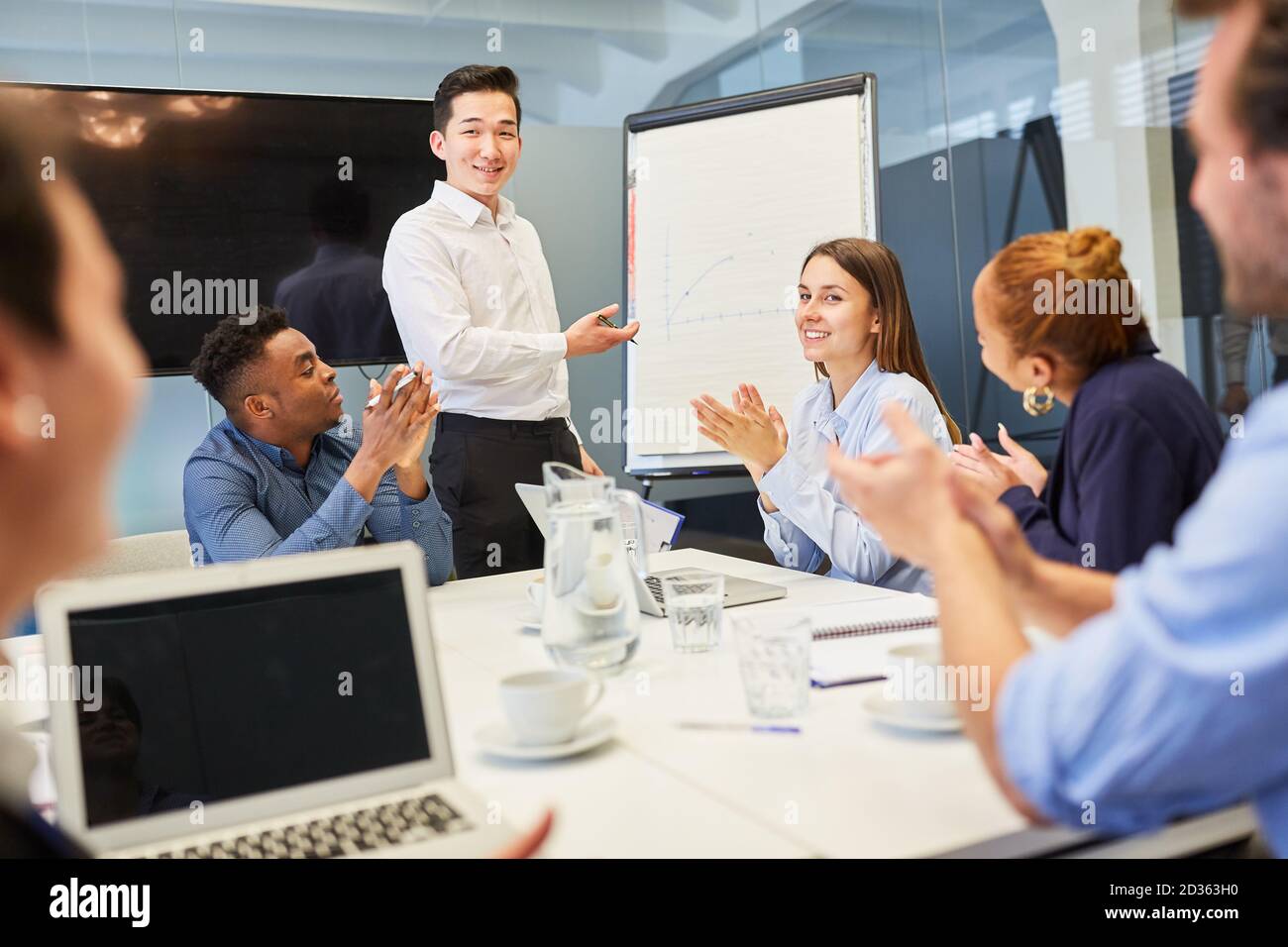 Business people in the start-up team clap after a presentation in the ...