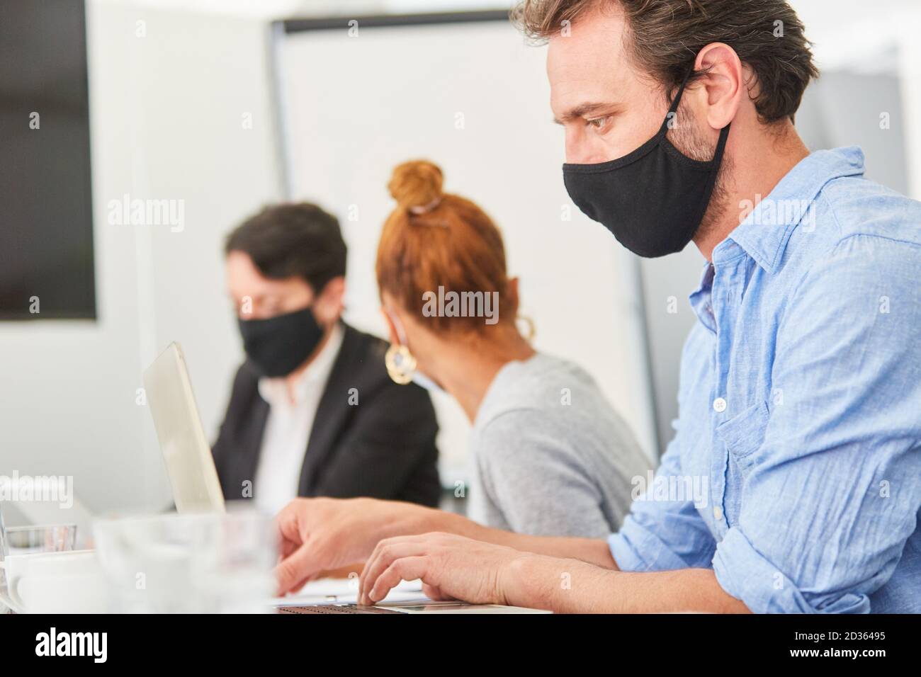 Business man with face mask because of Covid-19 in the office together ...