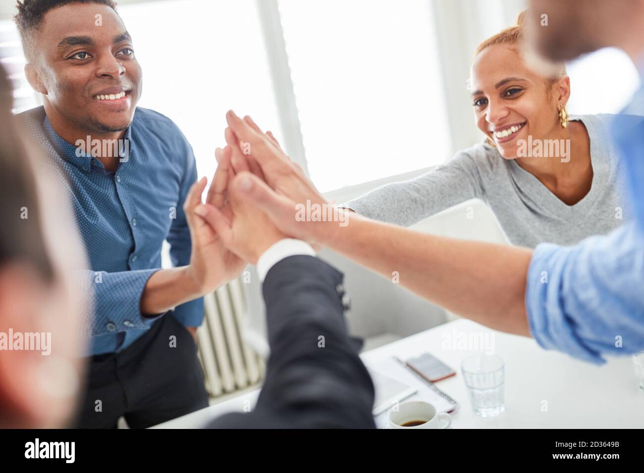 Multicultural start-up team at the high five for team spirit and ...