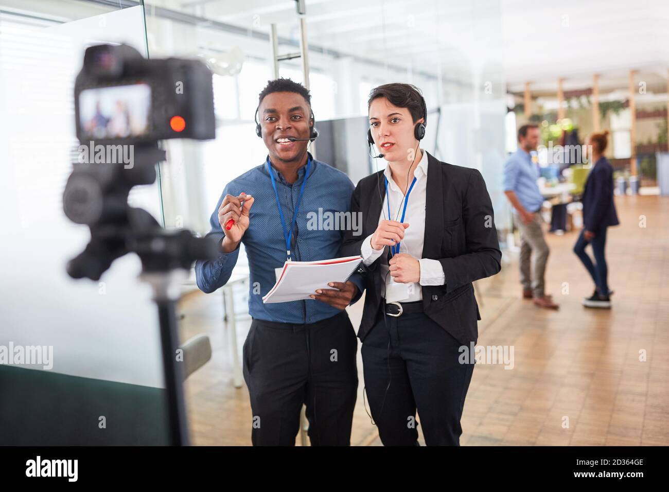 Two business people streaming live for a tutorial in front of the video ...