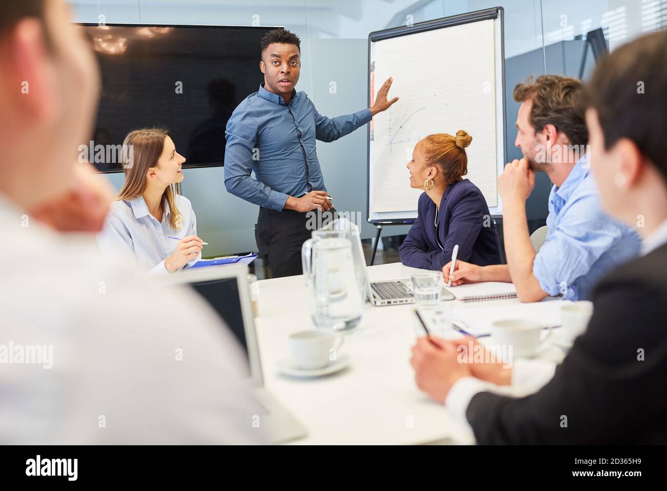 Young business man presenting project on flipchart in meeting Stock ...