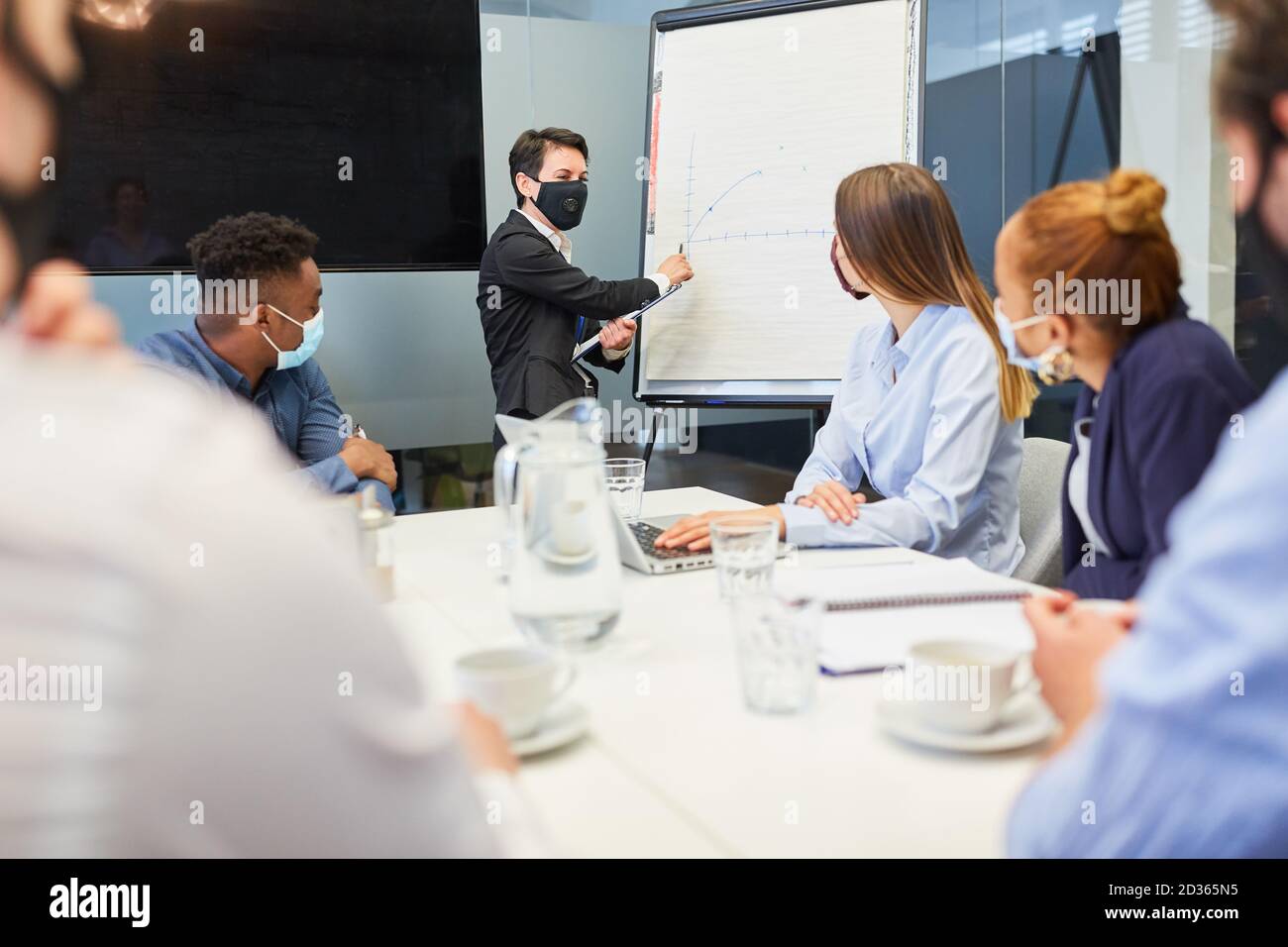 Consultant with face mask because of Covid-19 giving a presentation on ...