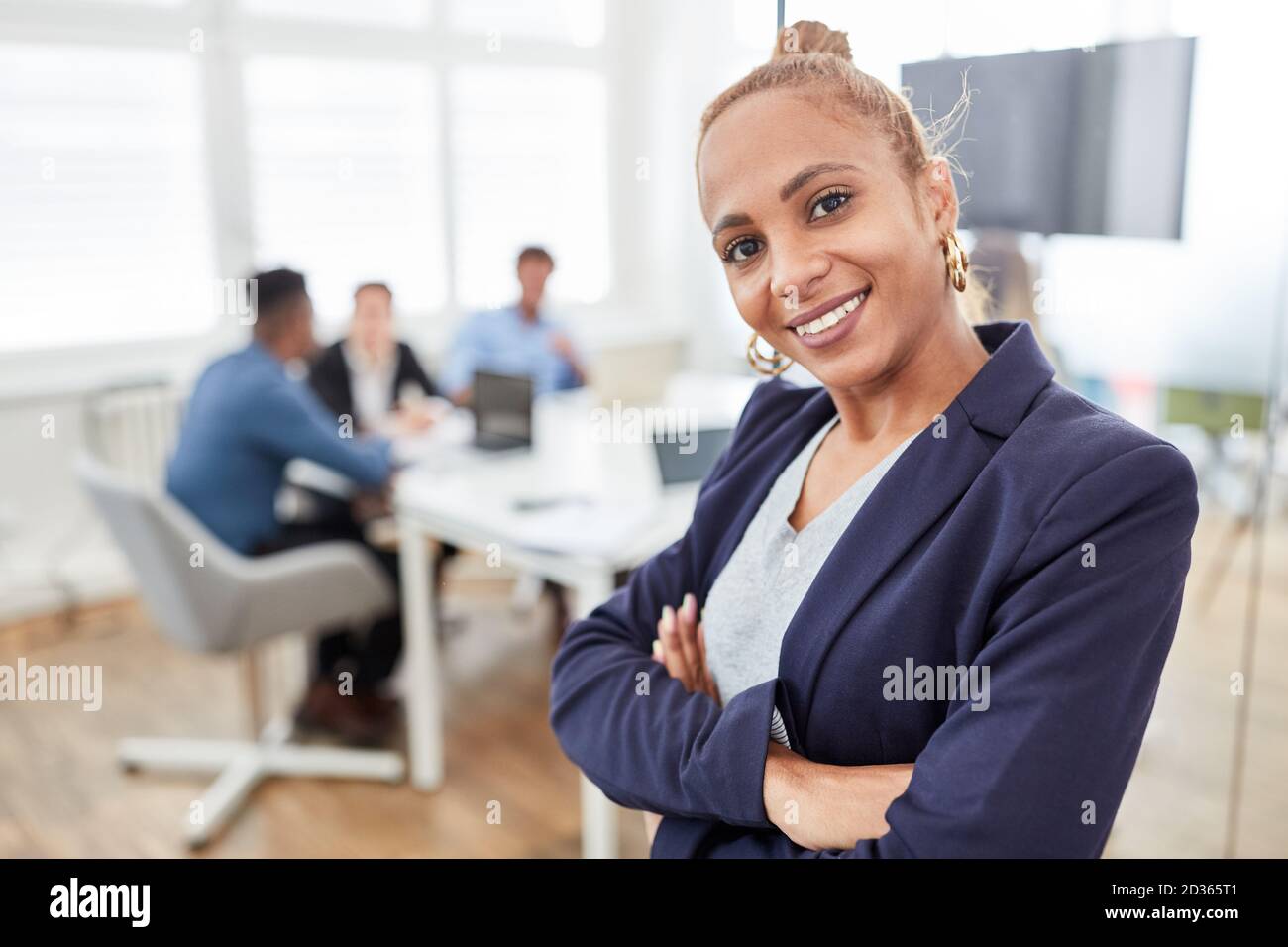 Smiling business woman as a trainee or young boss in front of her start ...