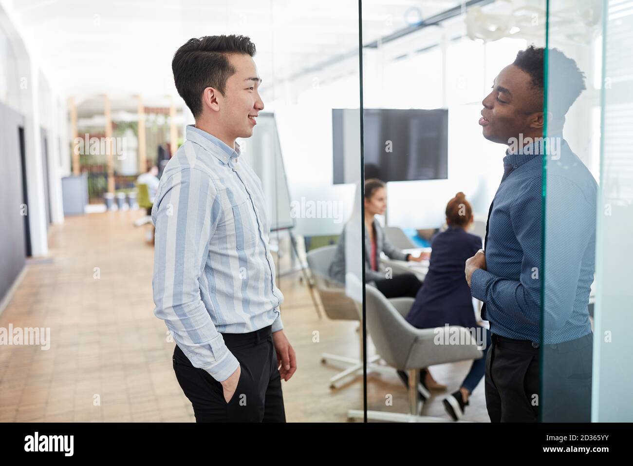 Two business people discussing with each other in a multicultural team ...