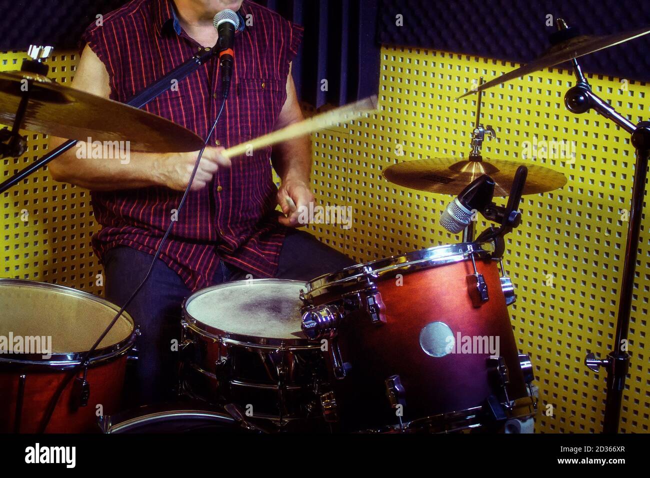 An elderly drummer plays in a recording Studio. A man of age sitting ...