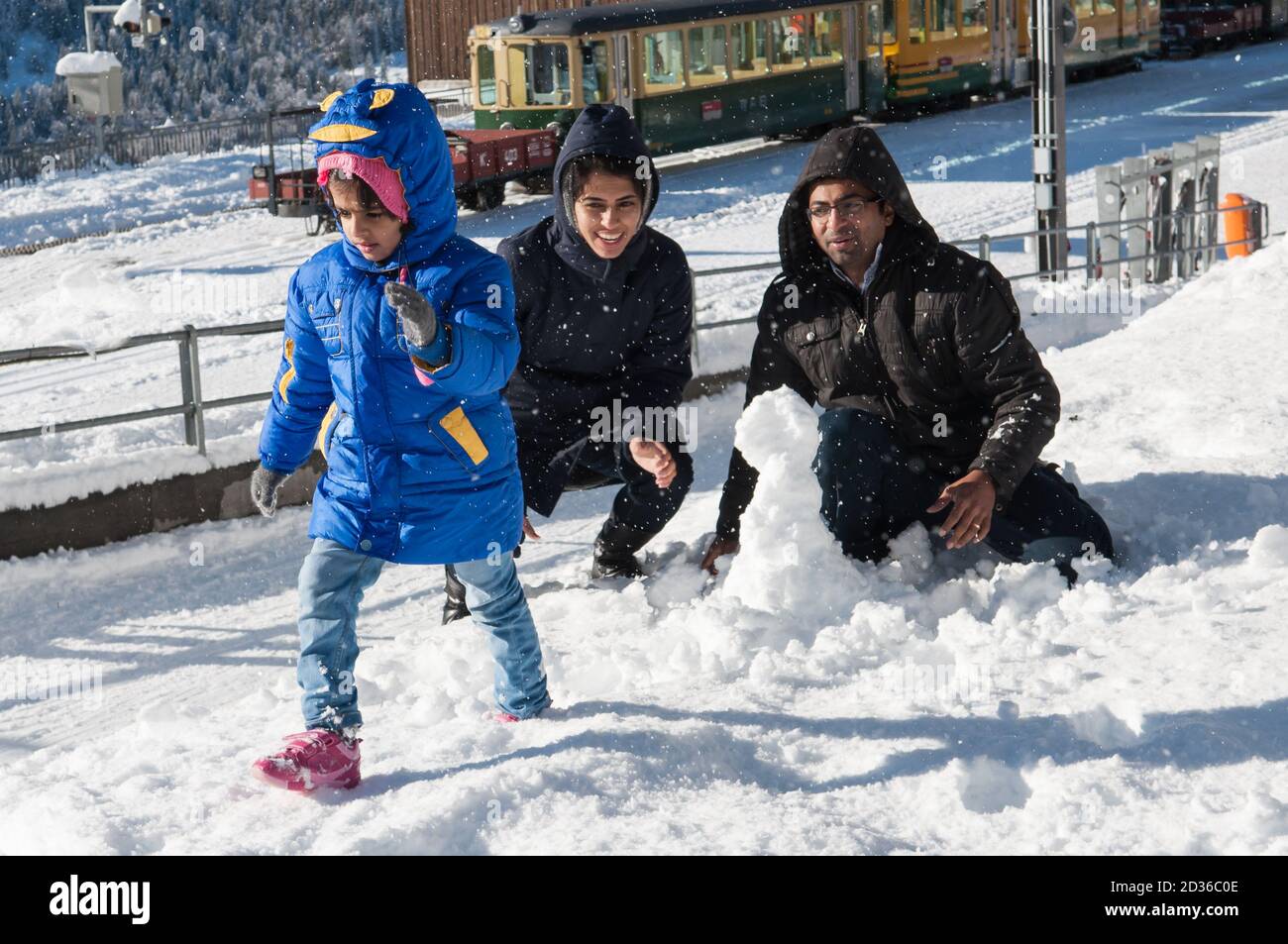 Happy Indian family playing with fresh white snow in Switzerland Shimla ...