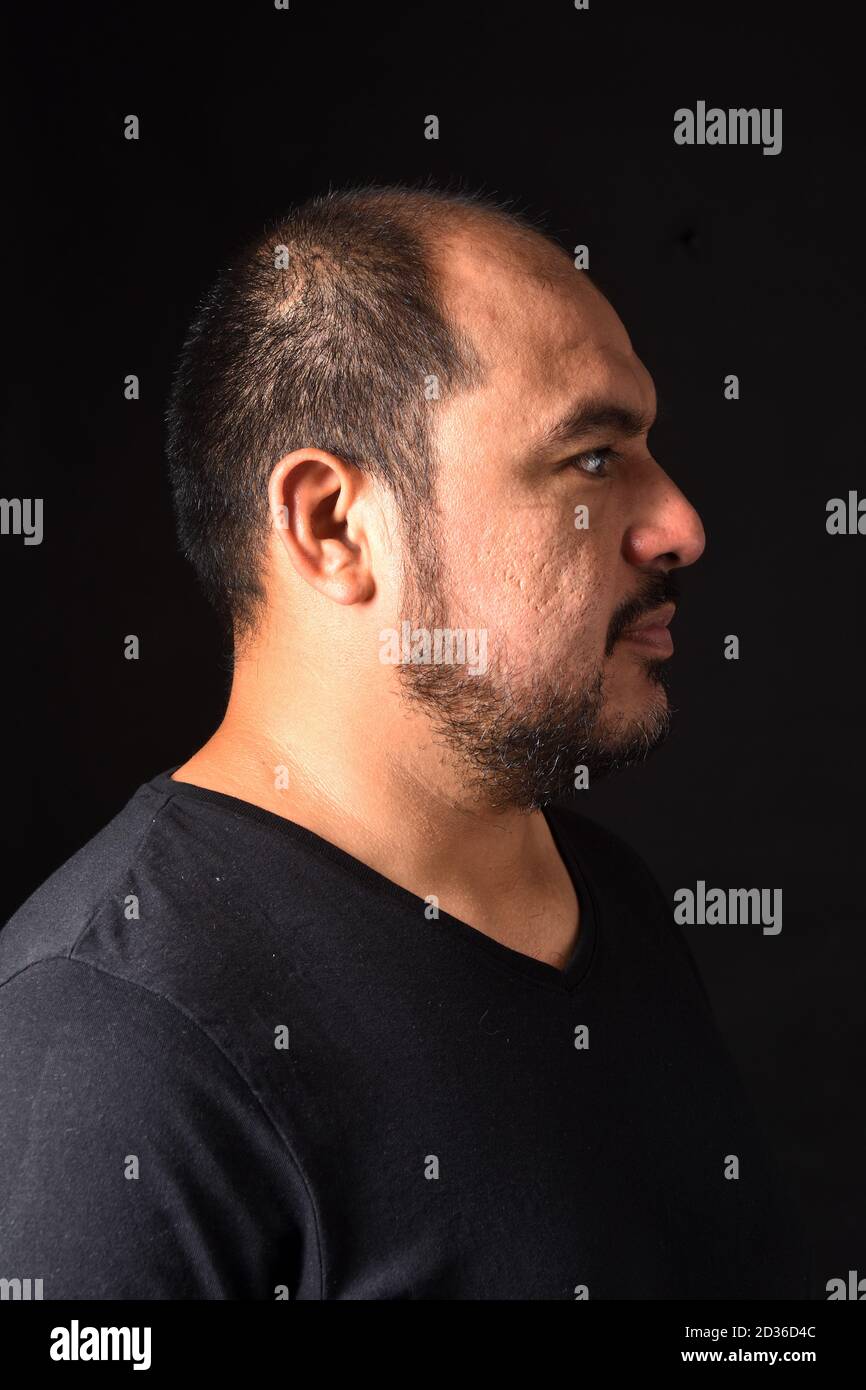side view portrait of a latin american man on black background Stock ...