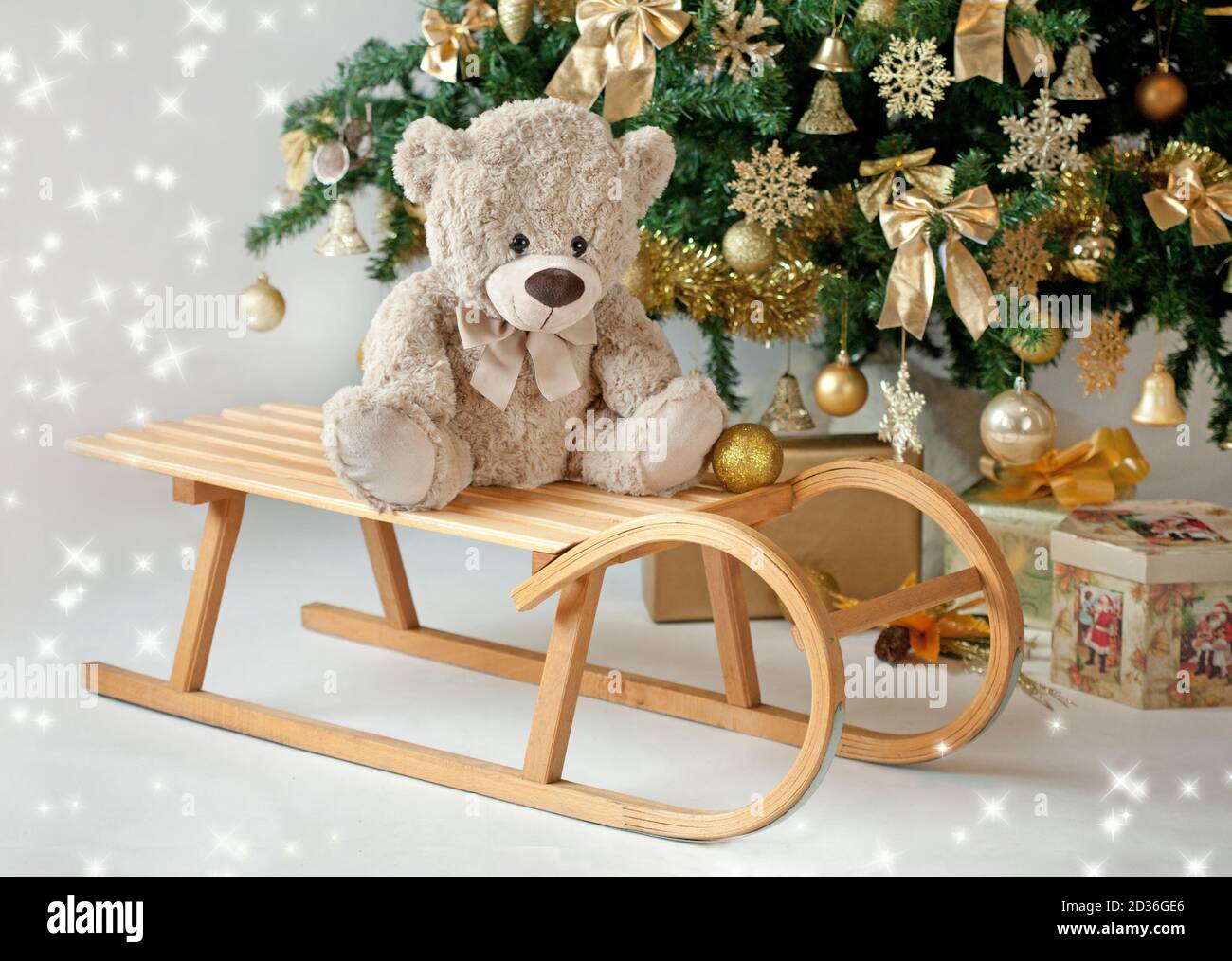 Christmas tree with golden ornaments, Teddy bears, a sledge and ...