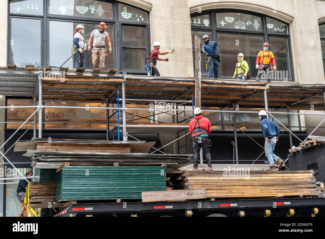 Workers form a human chain to construct scaffolding in the Flatiron ...